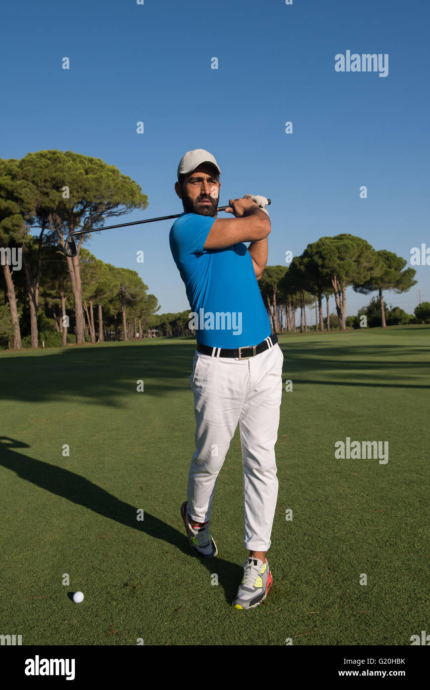 golf player hitting shot with club on course at beautiful morning with ...