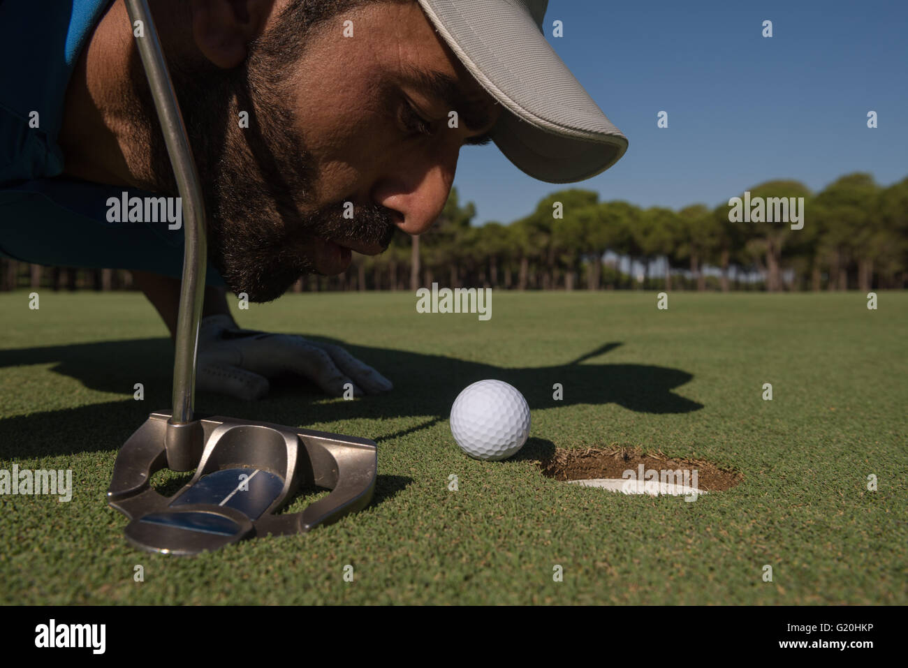 golf player blowing ball in hole. concept of cheating and success Stock ...