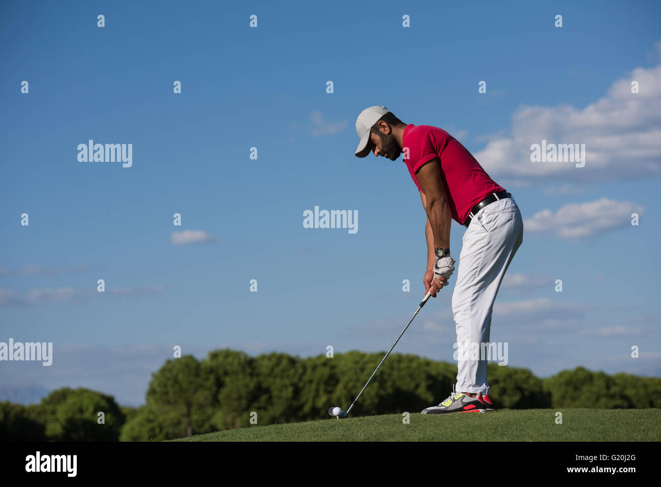 golf player hitting shot with driver on course at beautiful sunny day ...
