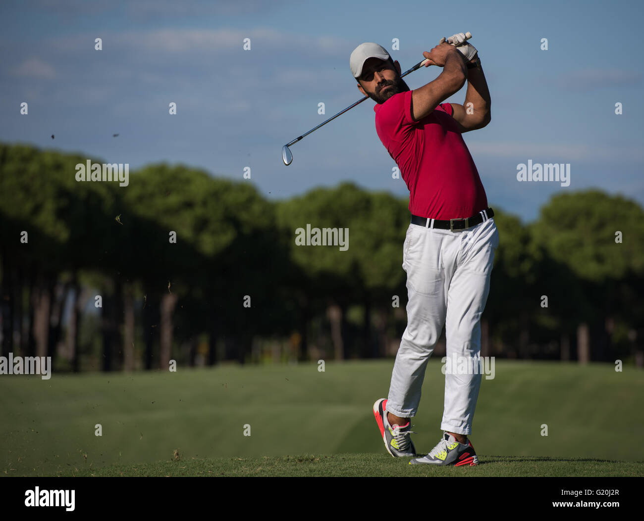 golf player hitting shot with driver on course at beautiful sunny day ...