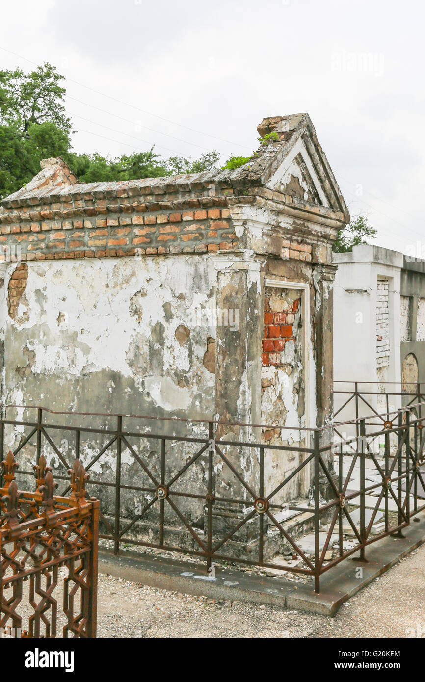 an old tomb constructed of brick and plaster with a metal fence Stock ...