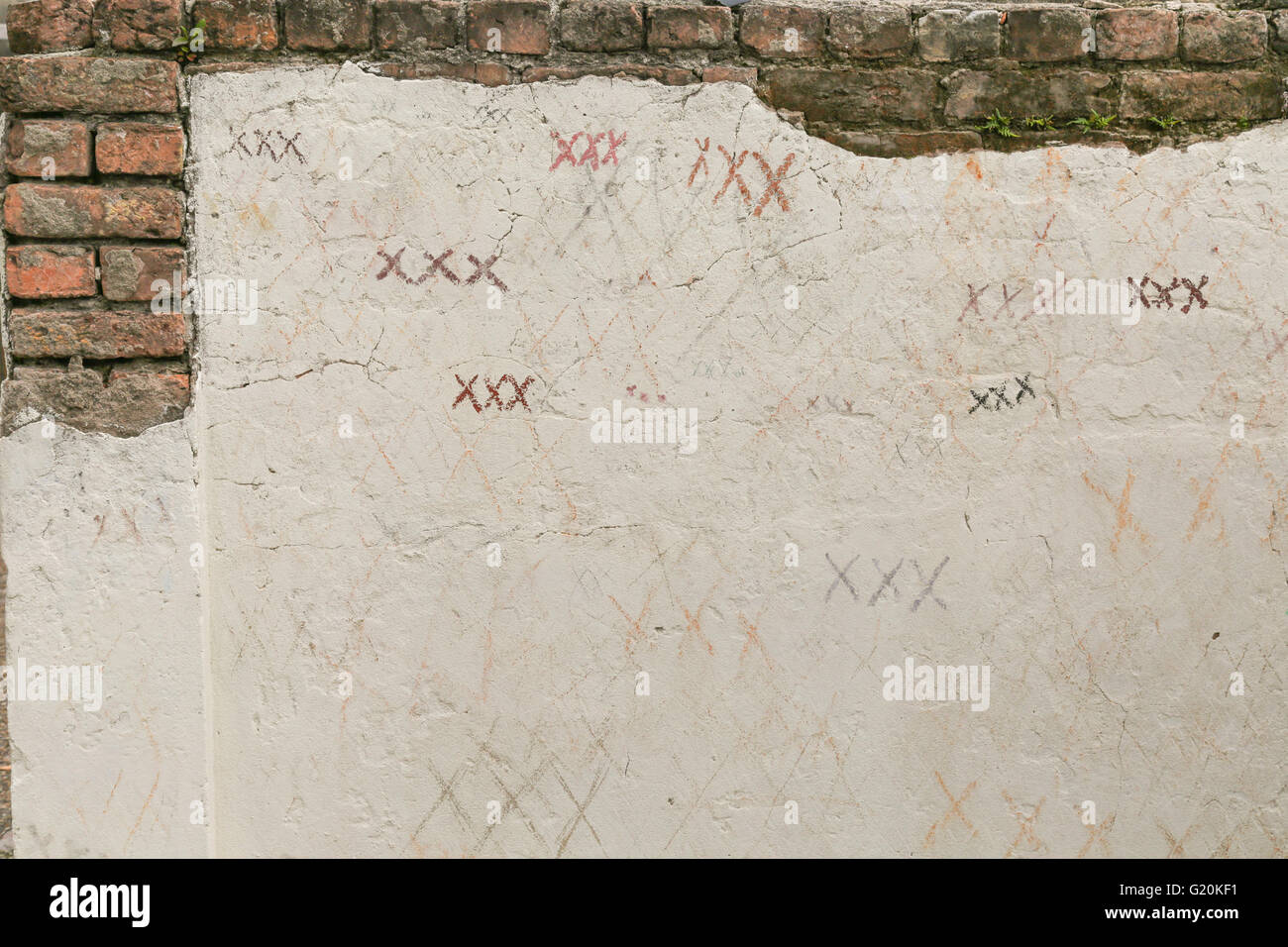 small and large X marks in groups of three (3) on a white plaster wall ...