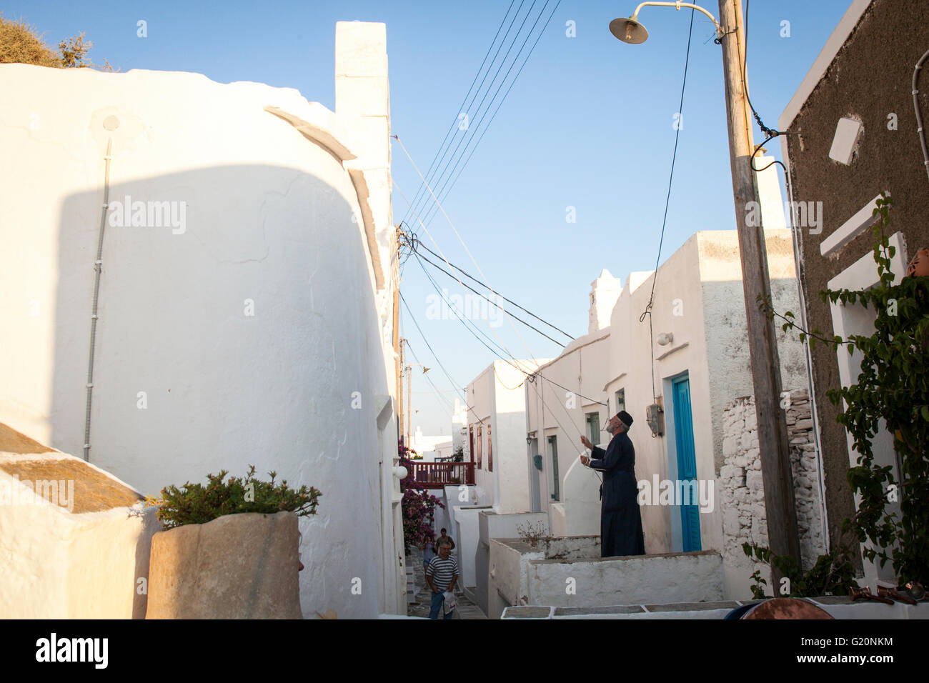 Old Christian Orthodox priest ringing the church bells, Sifnos island ...