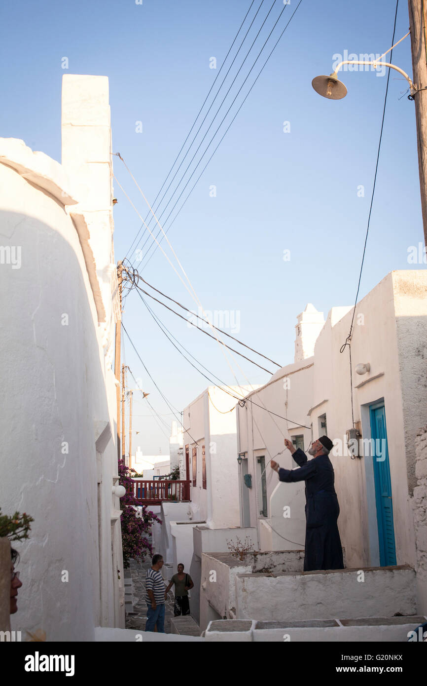 Old Christian Orthodox priest ringing the church bells, Sifnos island ...