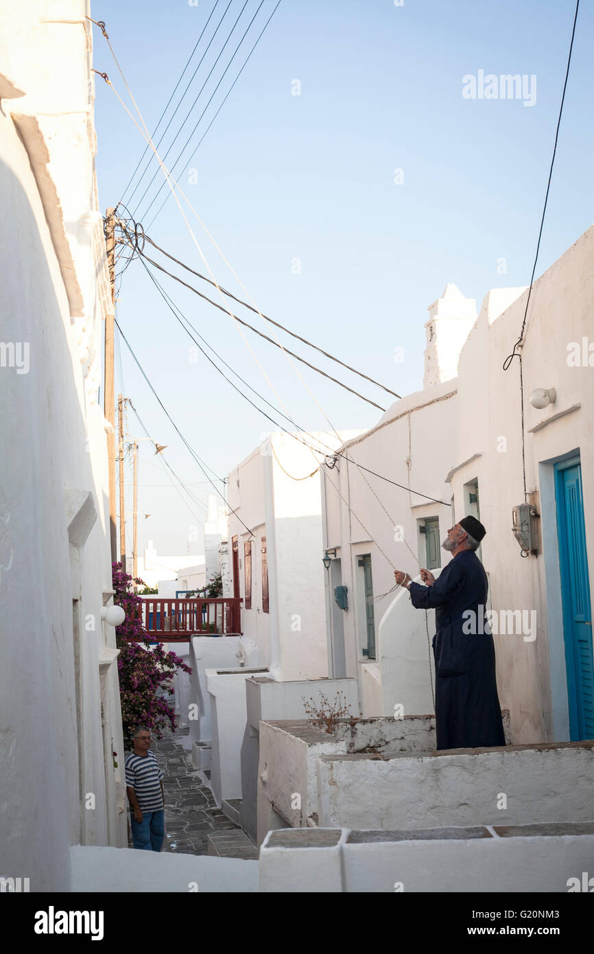 Old Christian Orthodox priest ringing the church bells, Sifnos island ...