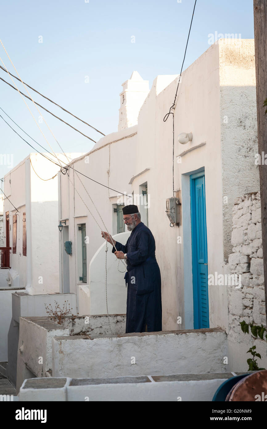 Old Christian Orthodox priest ringing the church bells, Sifnos island ...