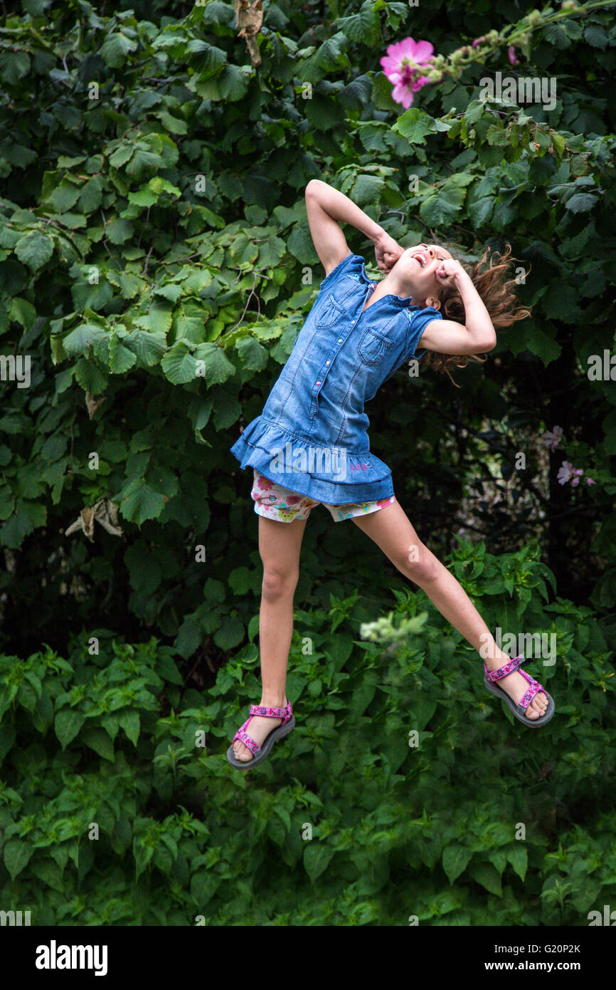 girl jumping playing and having fun at the garden, Greece Stock Photo ...