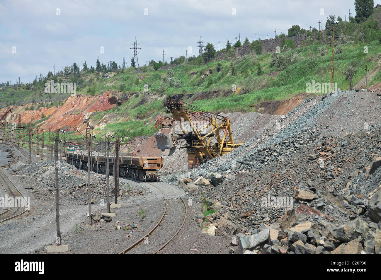 Excavator loading the iron ore to the cargo train on the opencast Stock ...