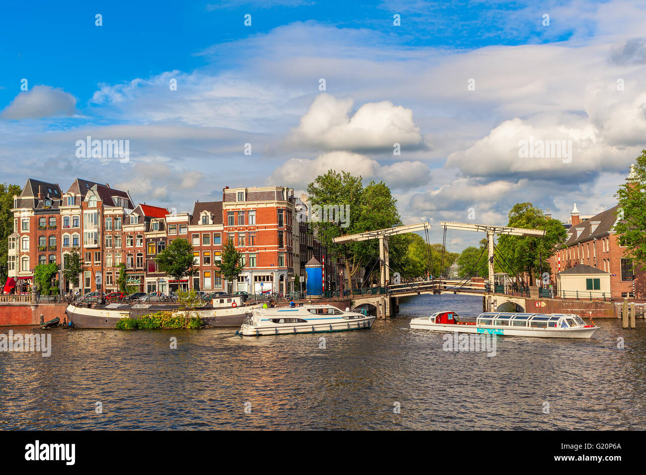 Boats on canal in front of small bridge and traditional houses under ...