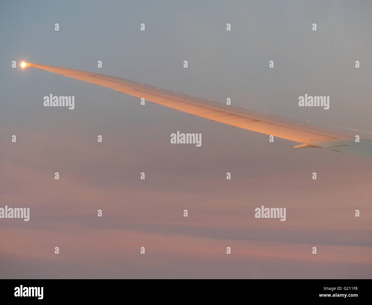 Wing of a Boeing 777-300ER jet aircraft illuminated by setting sun ...