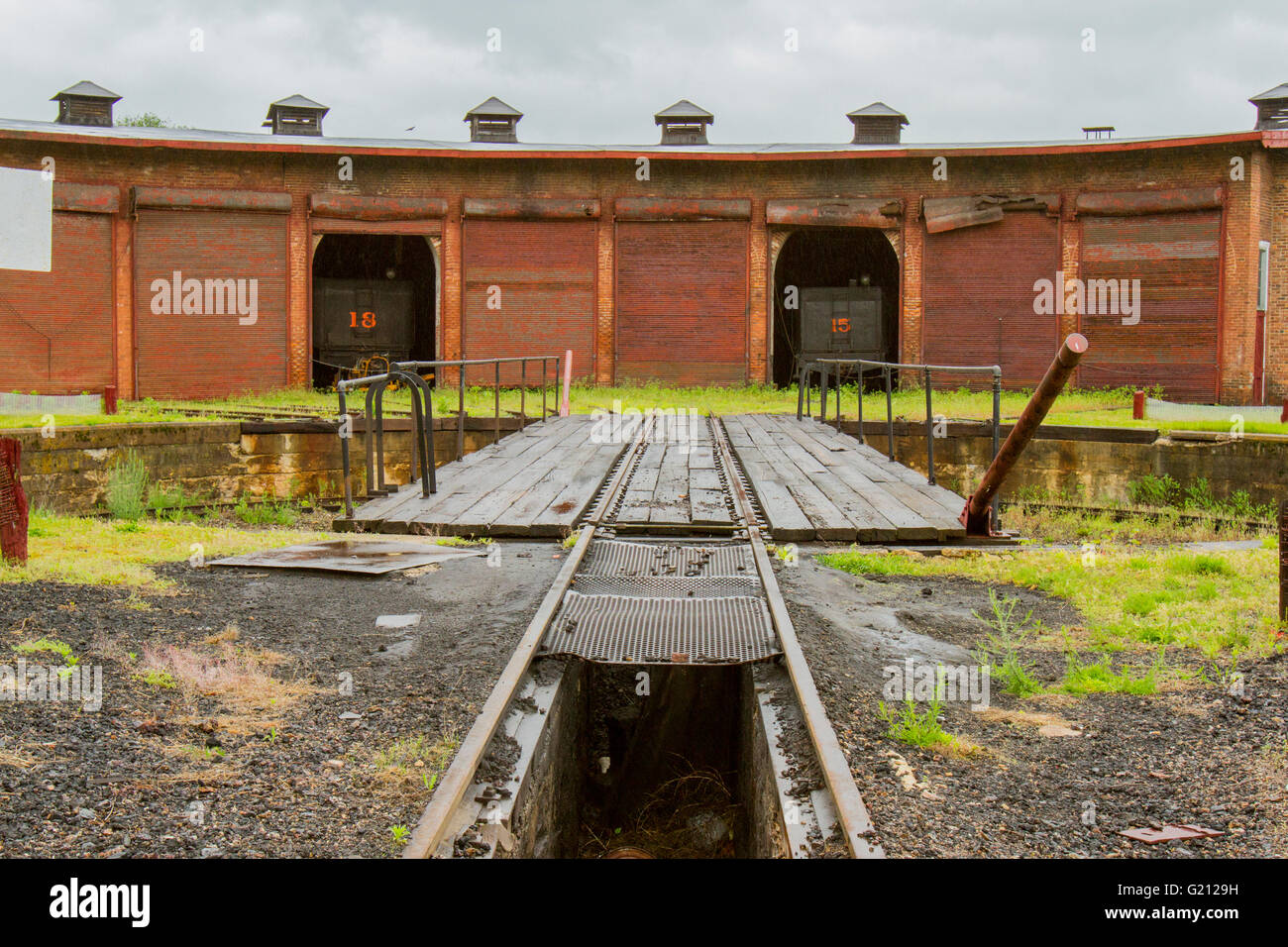 Tracks leading over bridge into maintenance round house with railroad ...