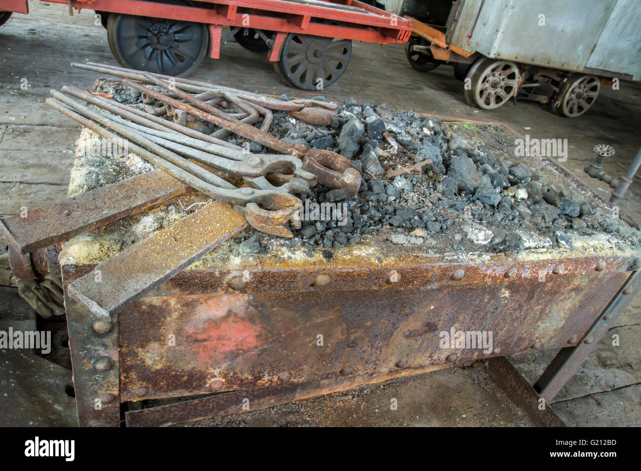 Blacksmith tools in coal burning pit in old railroad blacksmith shop ...