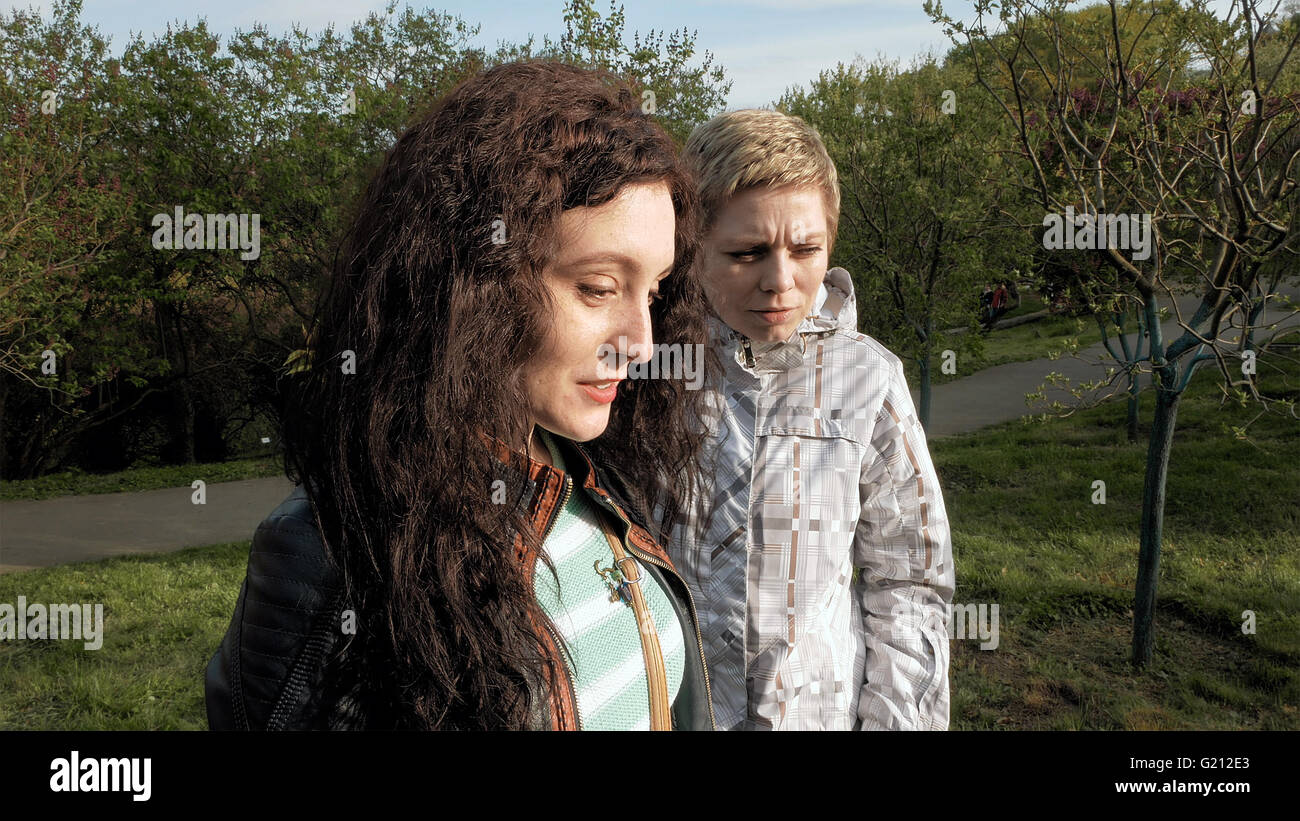 Two smiley girls friends talking in a green park Stock Photo - Alamy