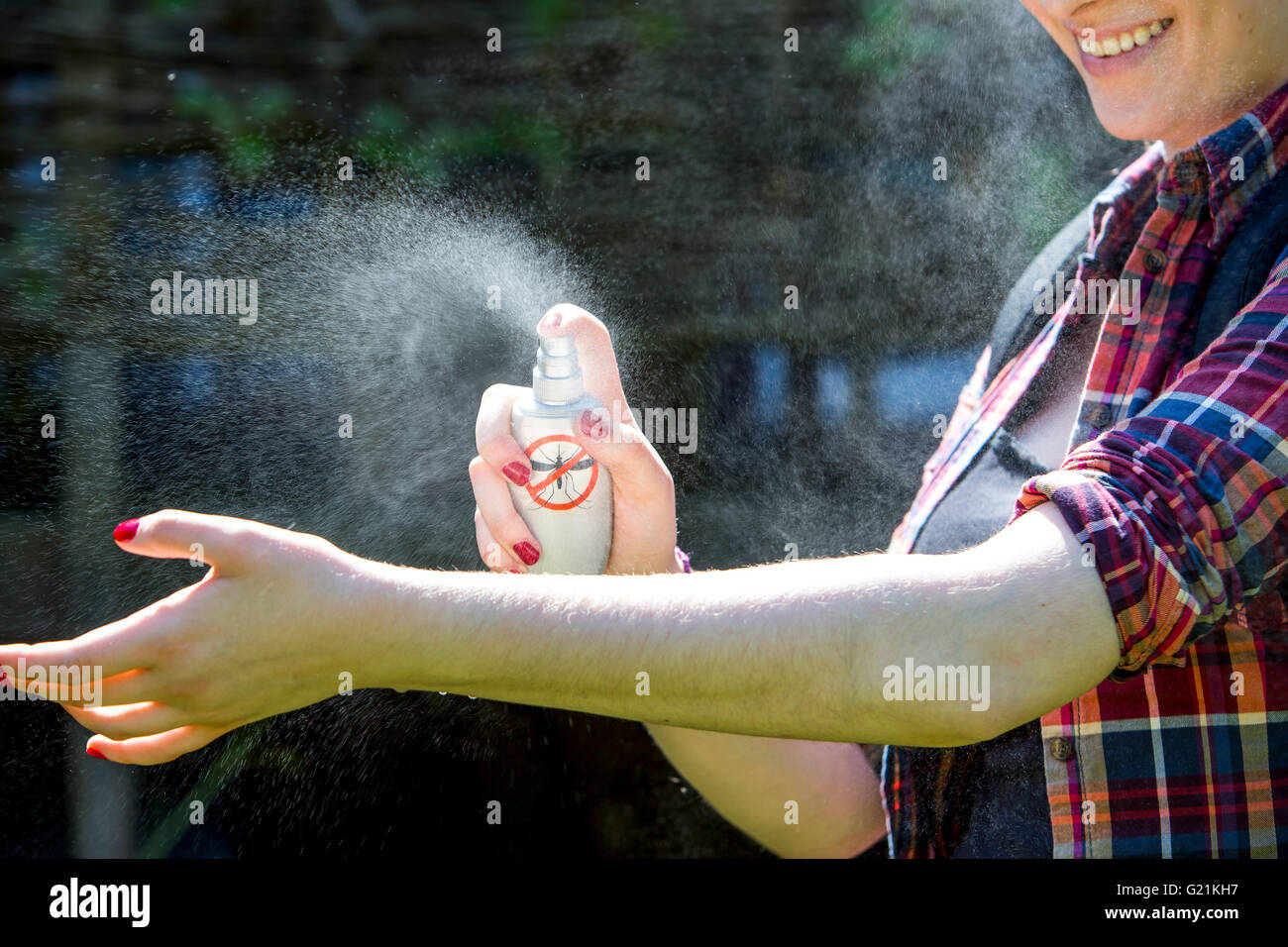 Mosquito repellent, young woman uses a spray repellent, before a hike ...