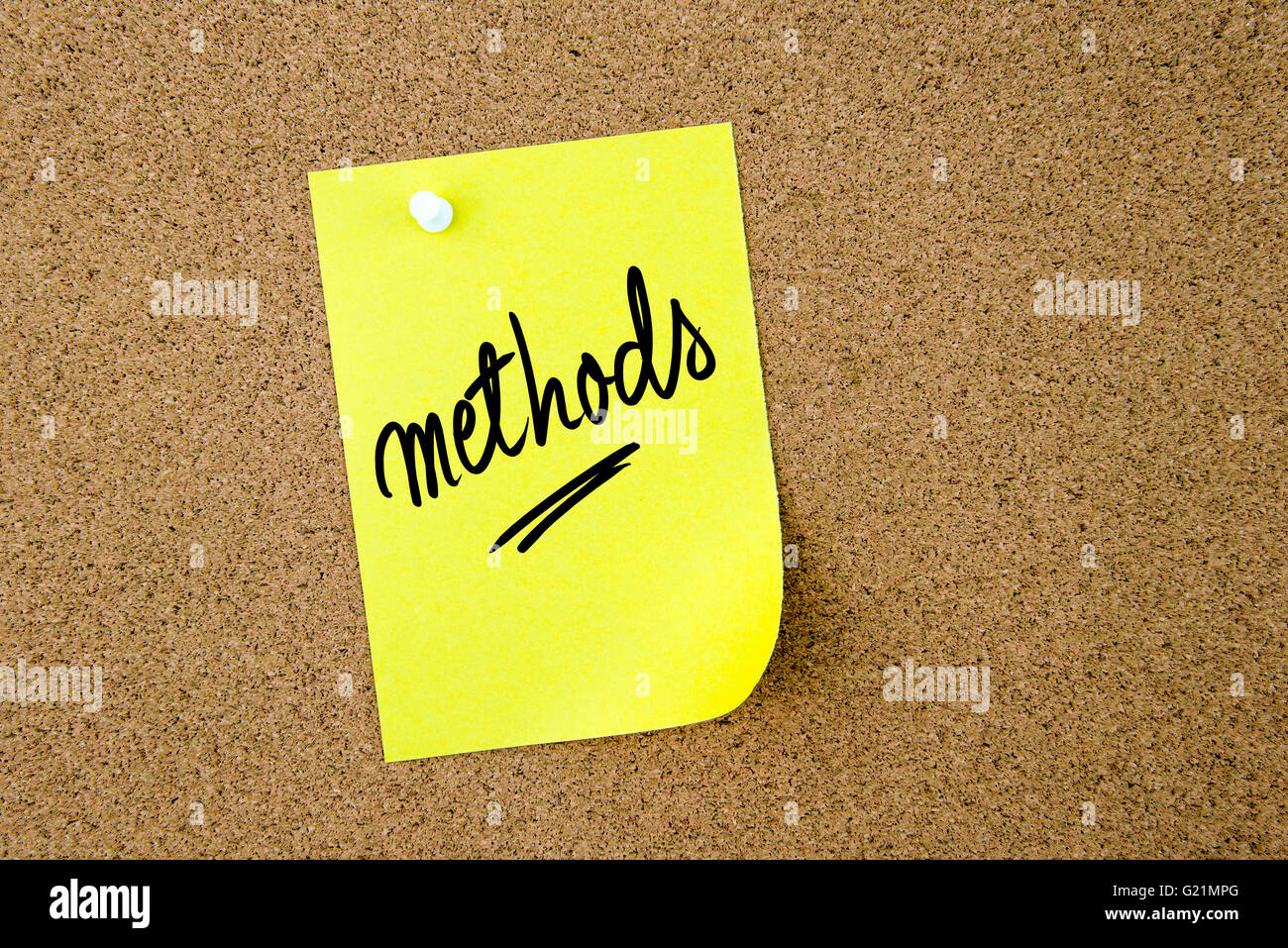 Methods written on yellow paper note pinned on cork board with white ...