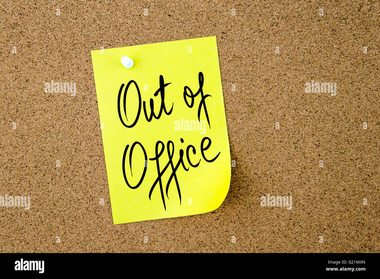 Out Of Office written on yellow paper note pinned on cork board with ...