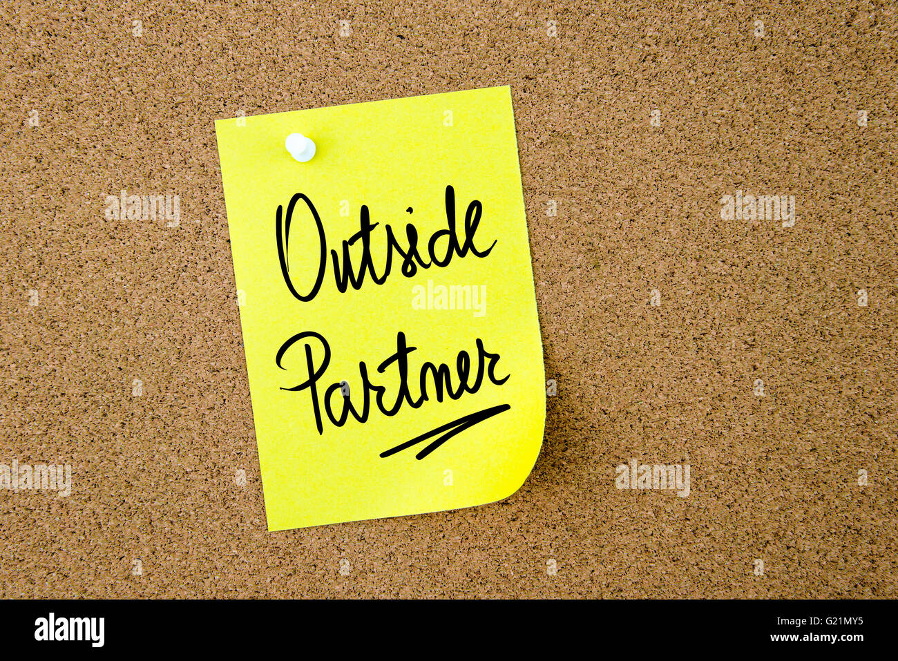 Outside Partner written on yellow paper note pinned on cork board with ...