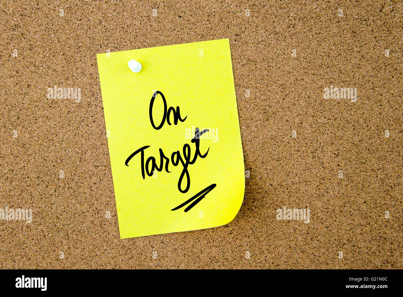 On Target written on yellow paper note pinned on cork board with white ...