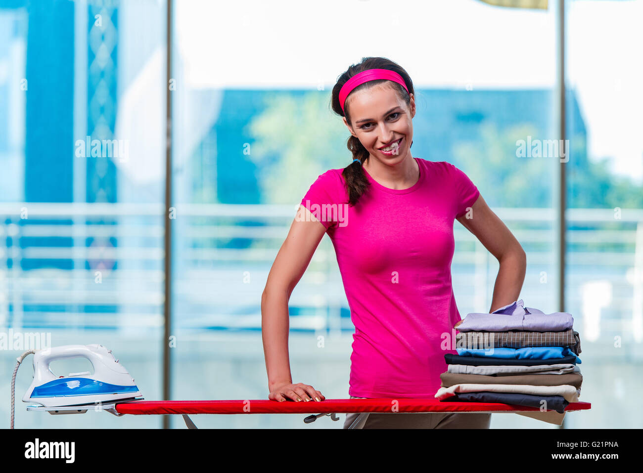 Young woman ironing clothing on board Stock Photo - Alamy