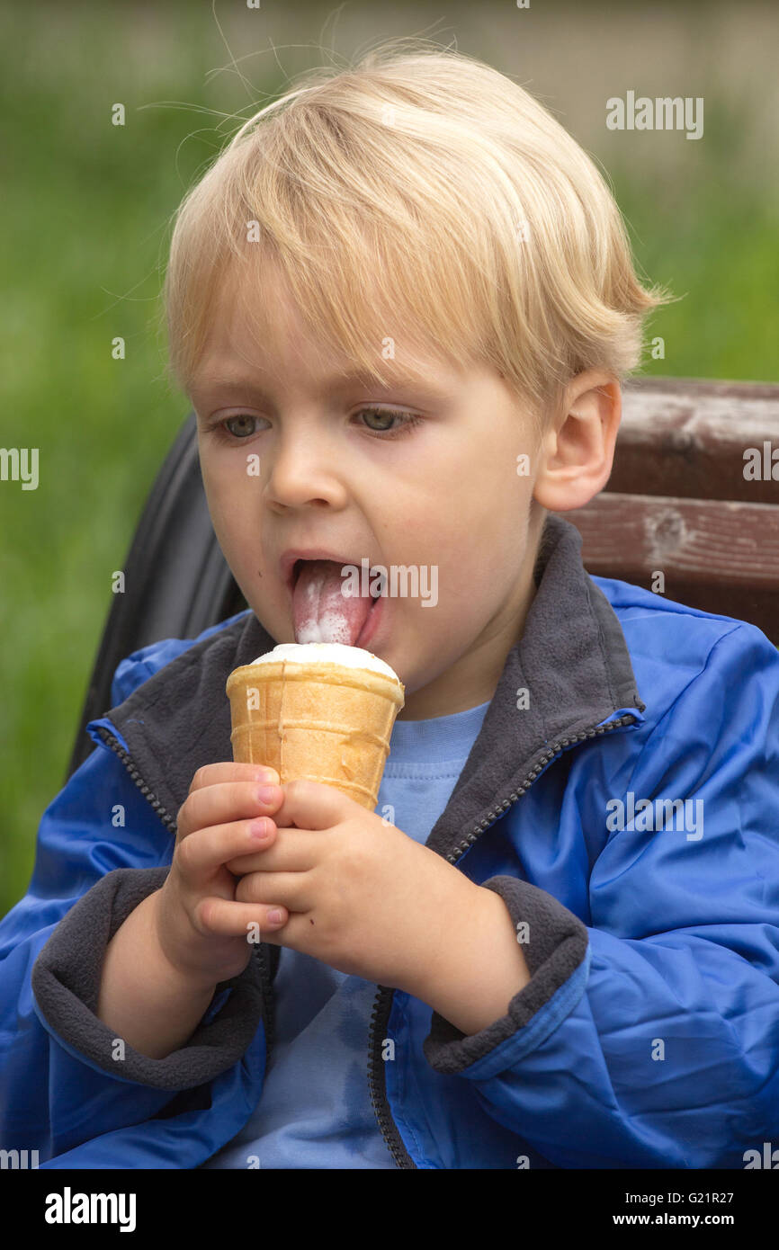 Blond boy eating ice cream outdoors Stock Photo - Alamy