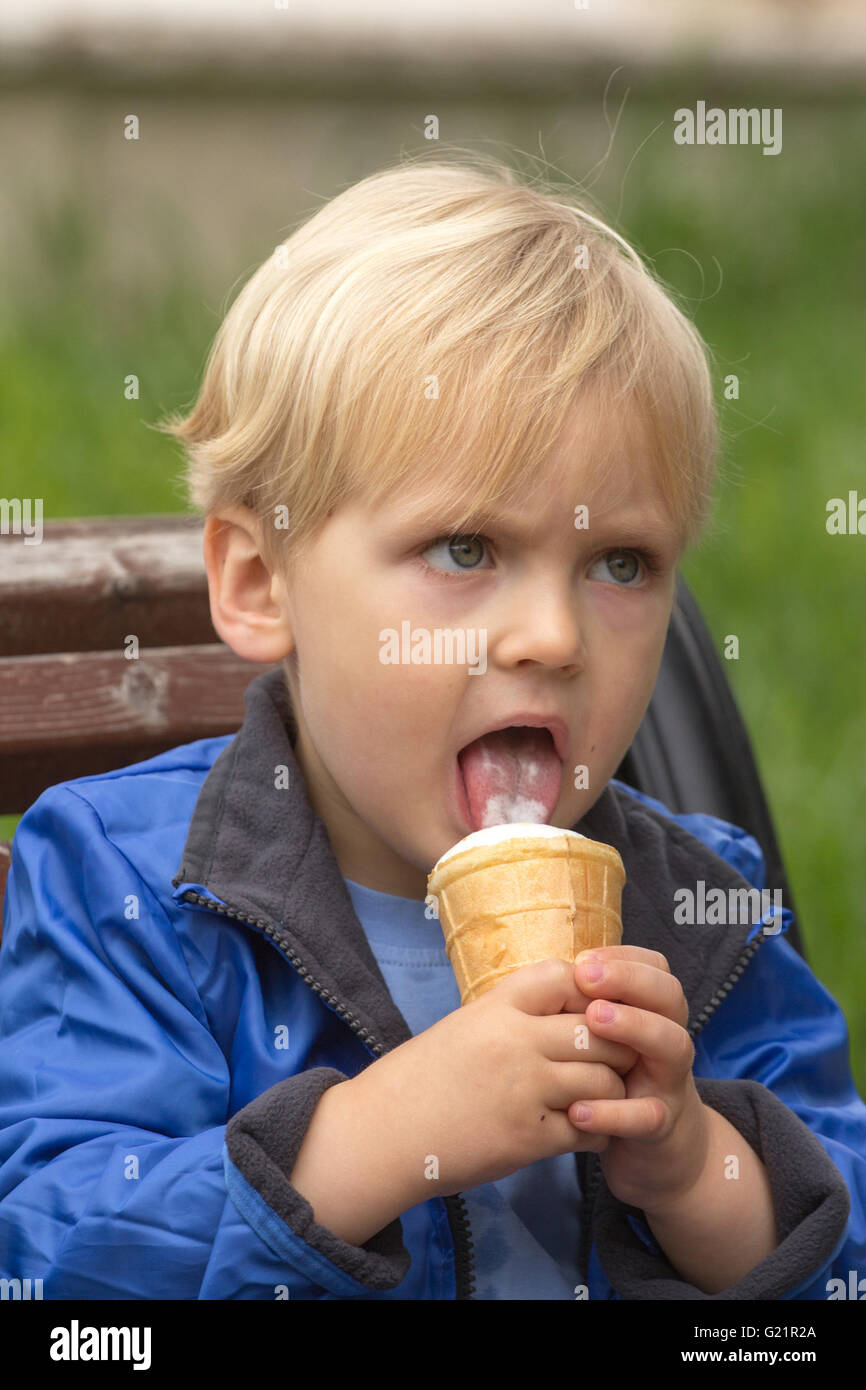 Blond boy eating ice cream outdoors Stock Photo - Alamy