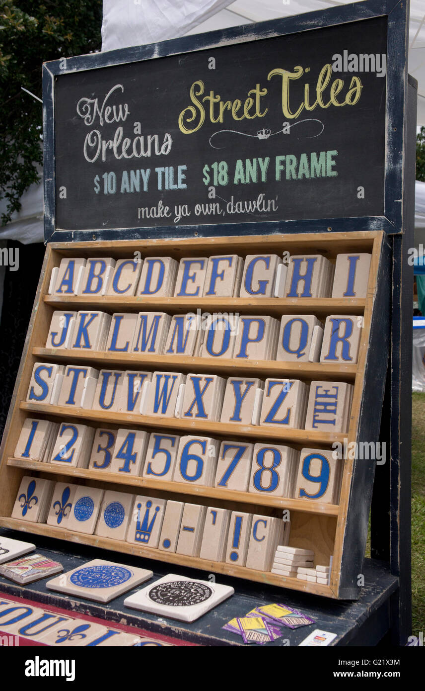 Artist selling reproductions of antique street tiles at an art fair in ...