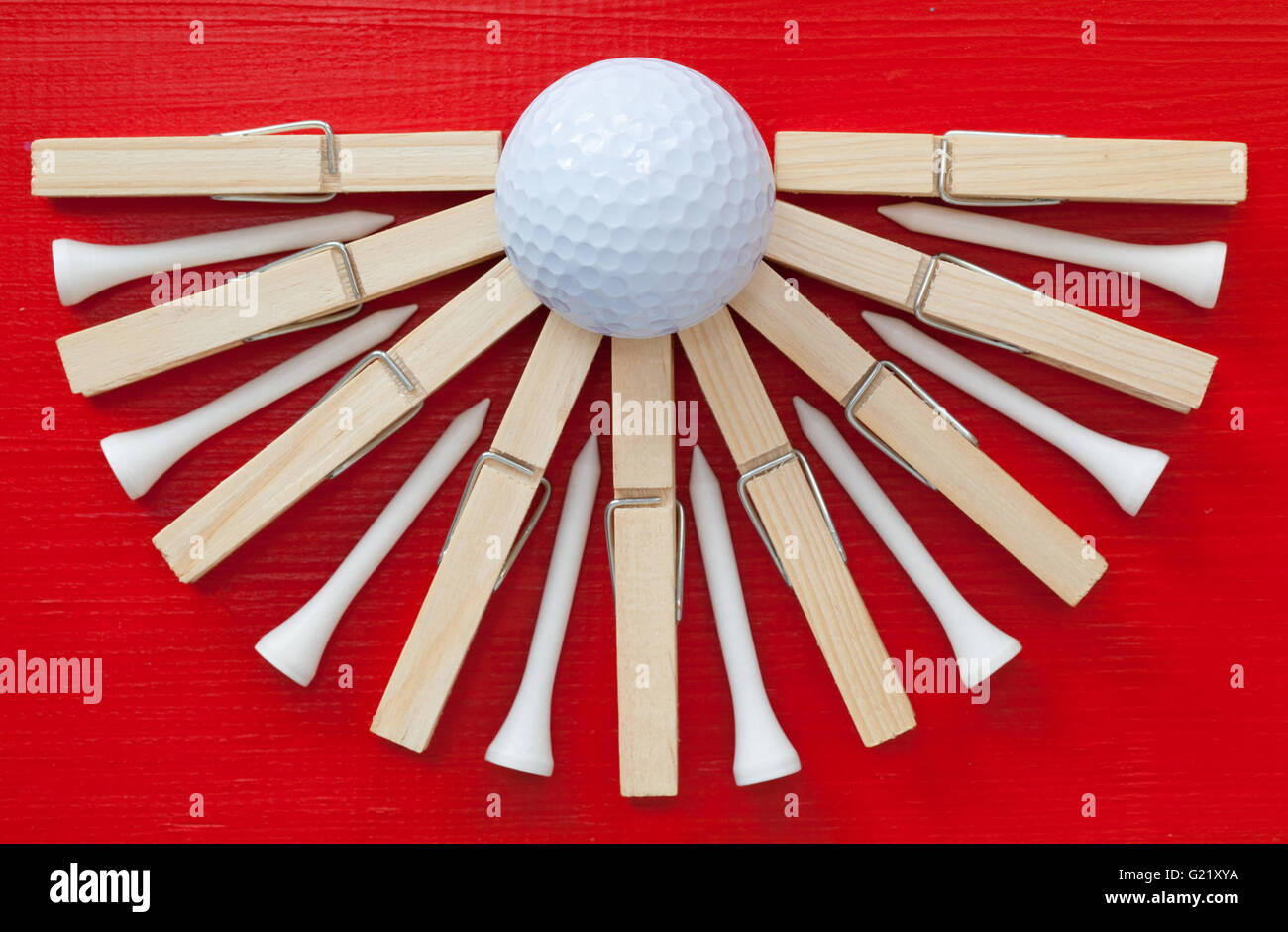 Set of cloth pegs and golf ball on wooden red table Stock Photo - Alamy