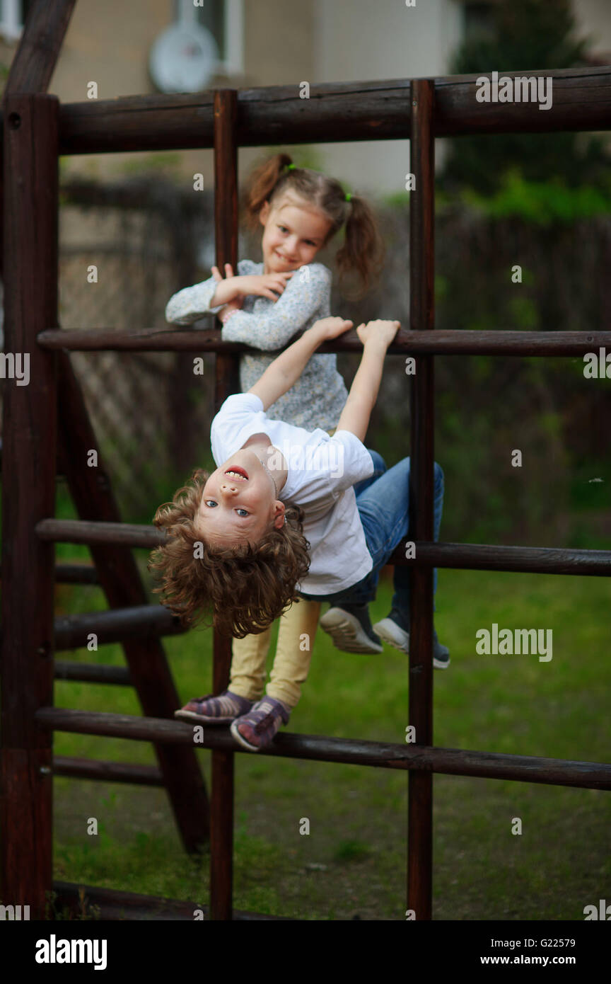 Girl and boy climb on the bars Stock Photo - Alamy