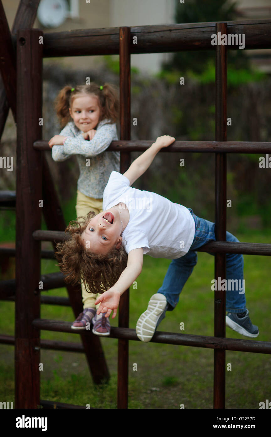 Two children climb on the bars while playing in the yard Stock Photo ...