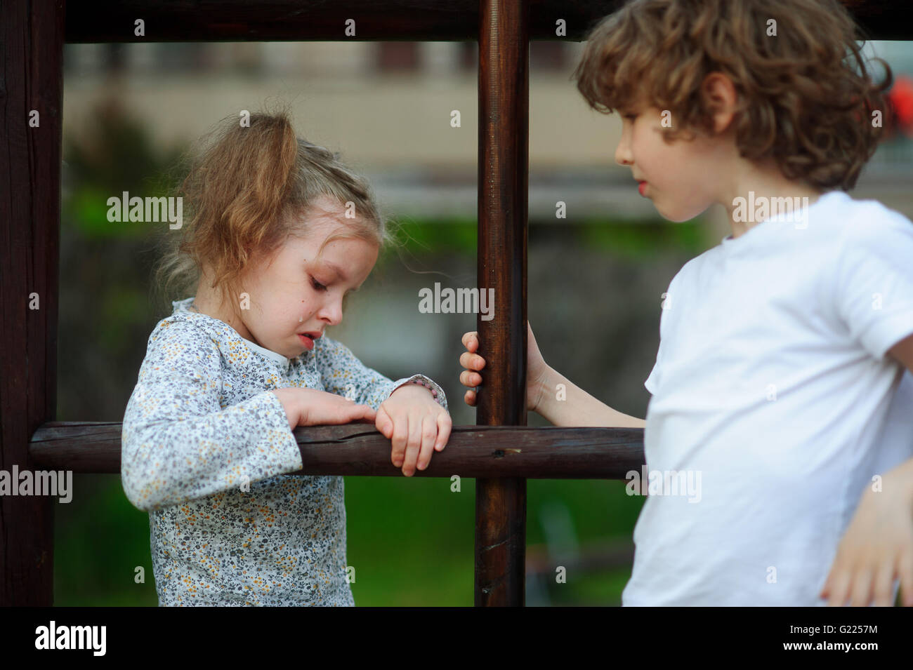 Little girl standing on the playground next to the boy and crying Stock ...