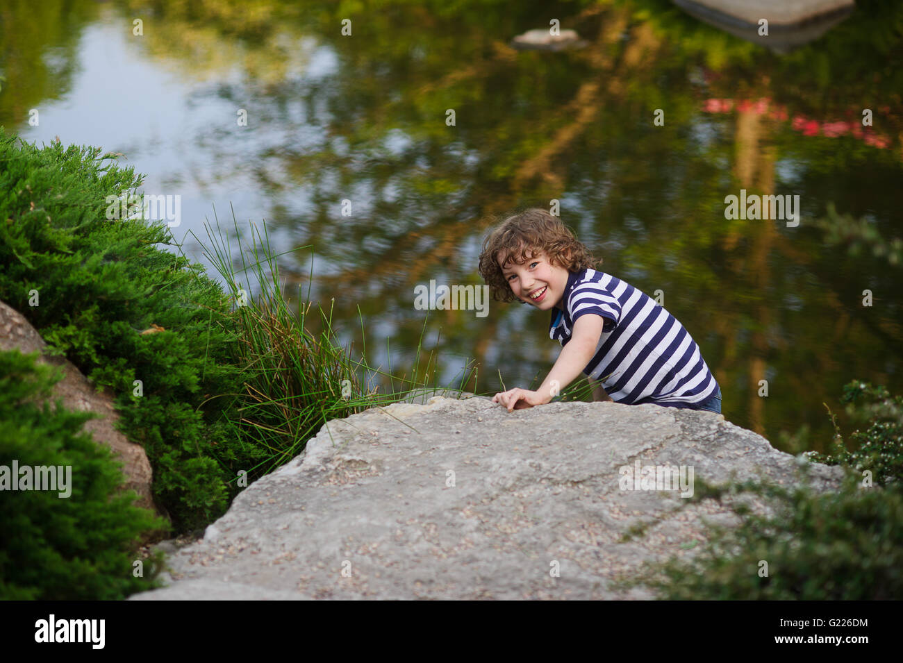 Boy playing by a pond Stock Photo - Alamy