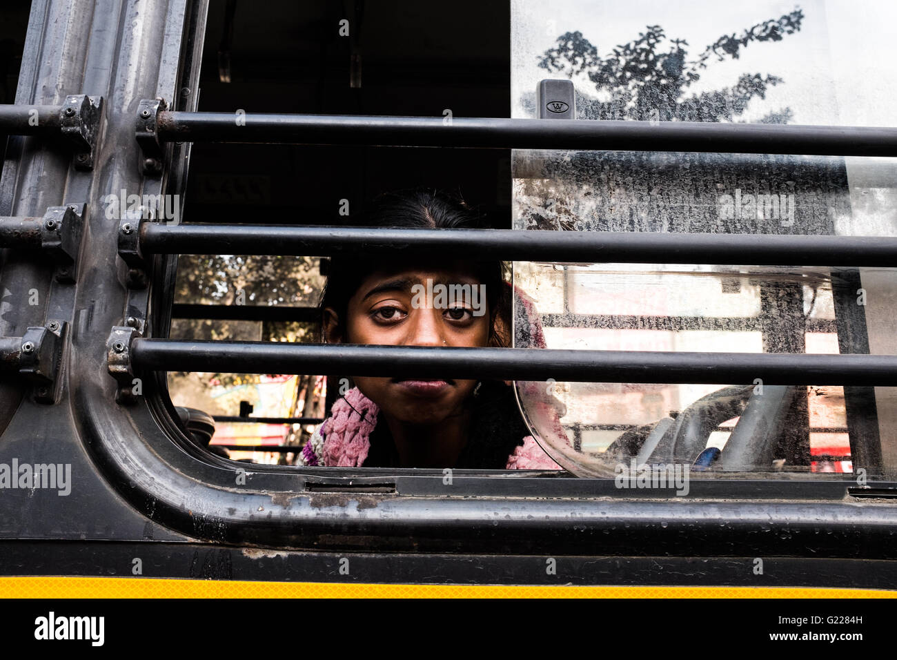 Child looking through bars of a bus in Delhi, India Stock Photo - Alamy