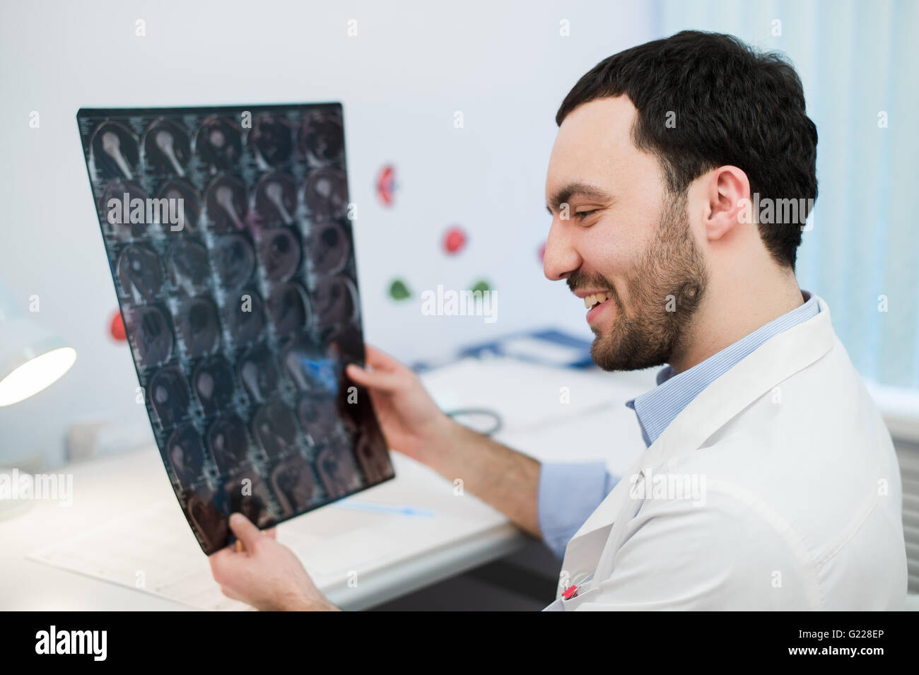 Young male physician reading and reviewing a MRI brain scan Stock Photo ...