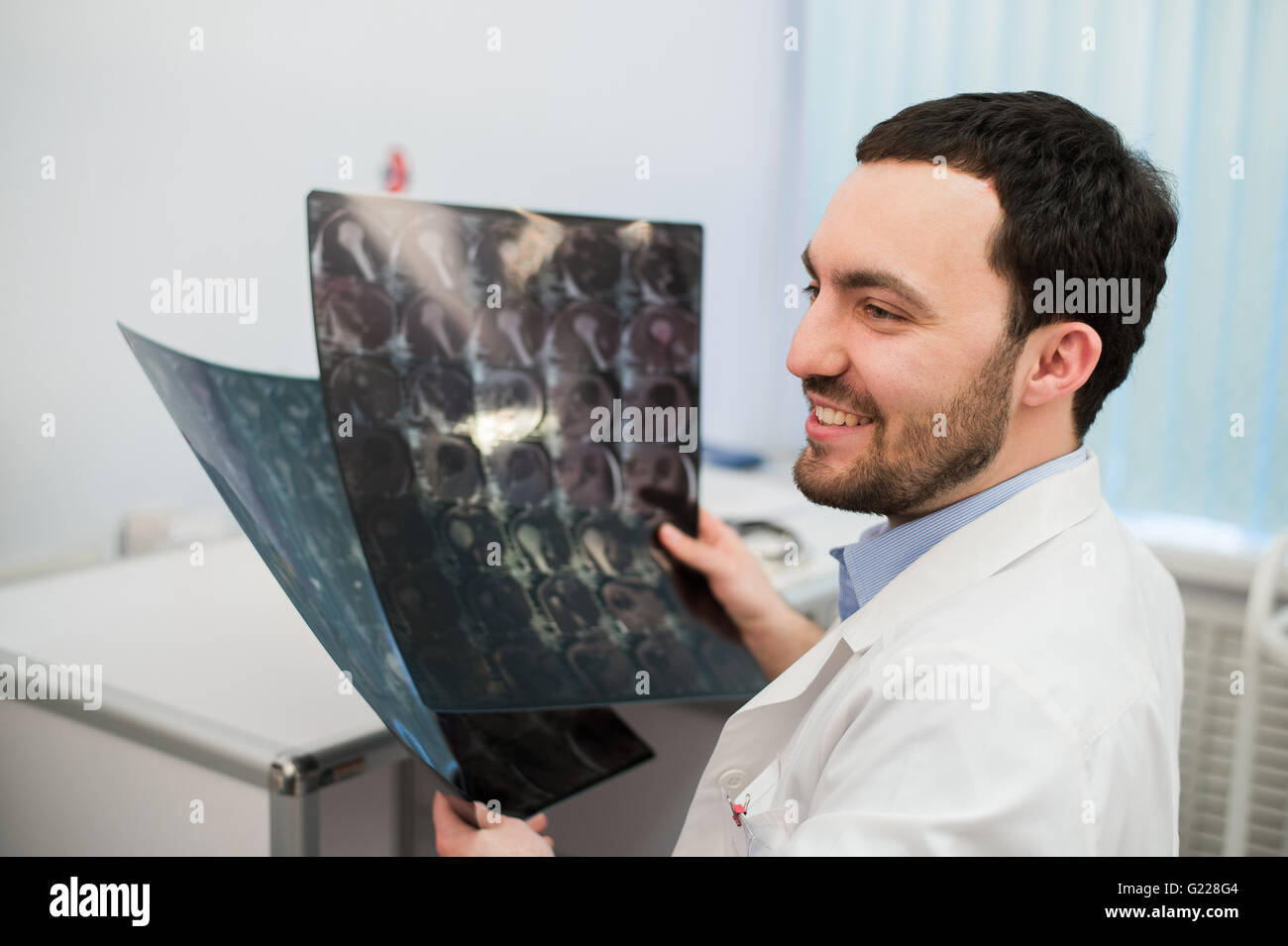 Portrait of a happy caucasian male radiologist holding x-ray while ...