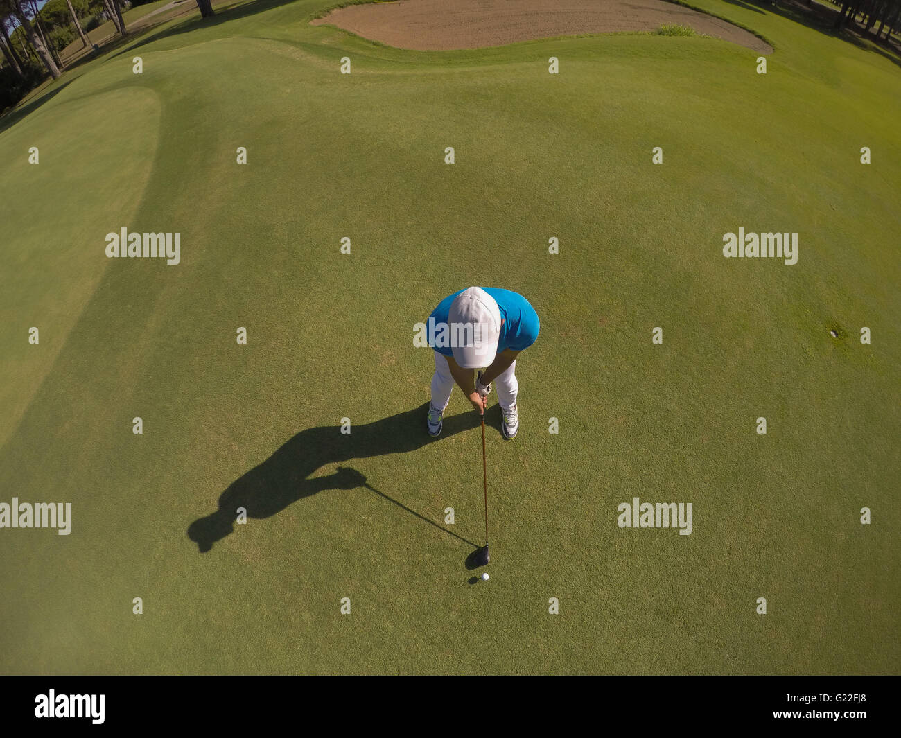 top view of golf player hitting shot with club on course at beautiful ...