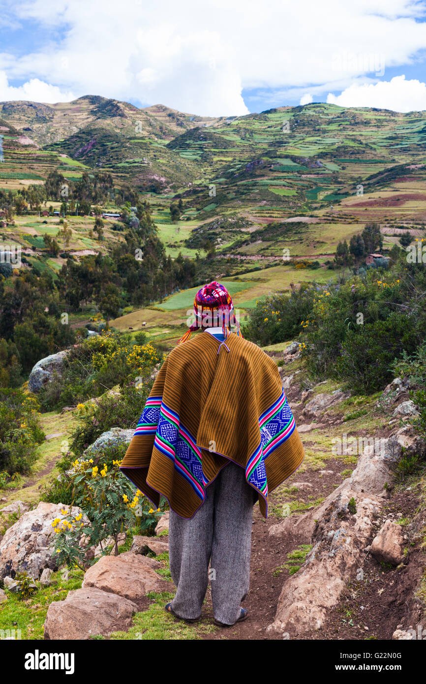 Peruvian farmer looking out over the fields above the village of ...