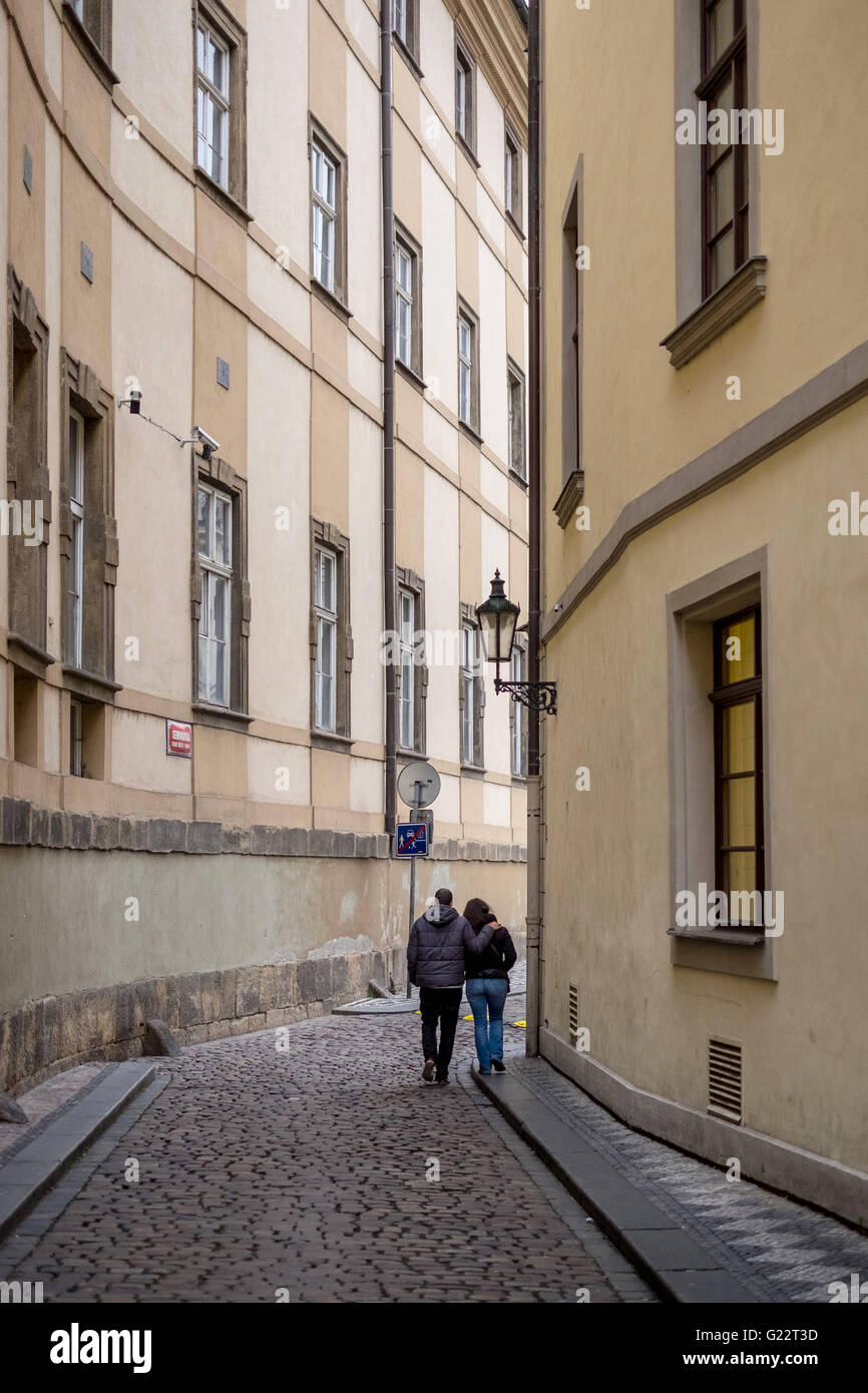 A young couple make their way arm in arm through the back streets of ...