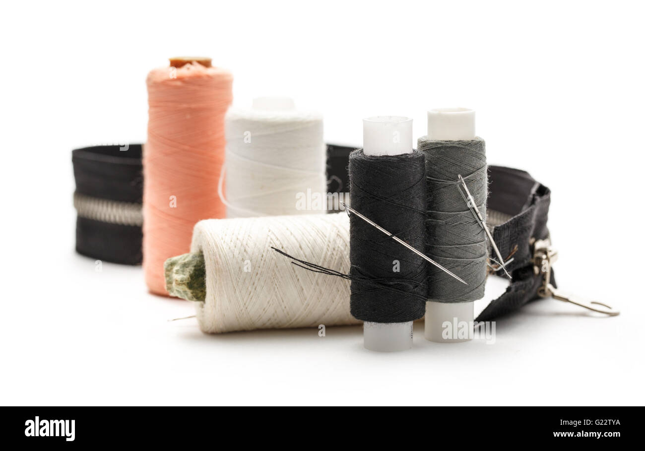 Thread bobbins and needles on white background Stock Photo - Alamy