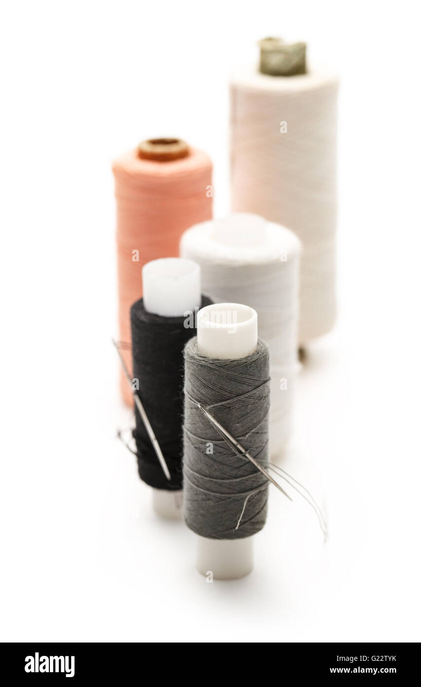 Thread bobbins and needles on white background Stock Photo - Alamy