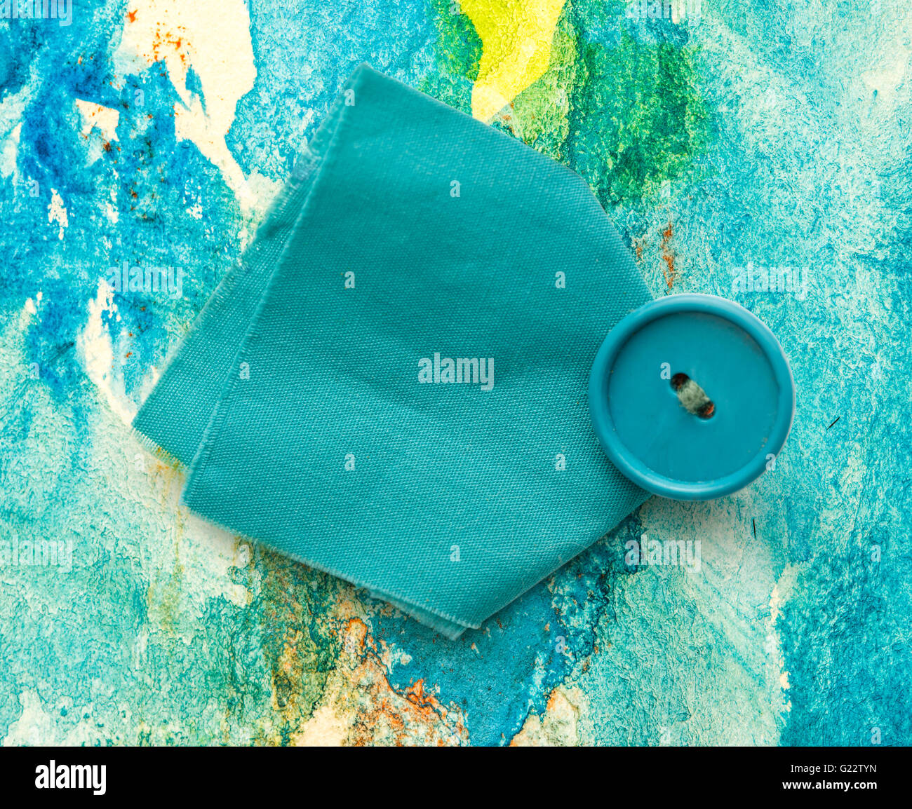 Piece of blue cloth with button on colorful background Stock Photo - Alamy