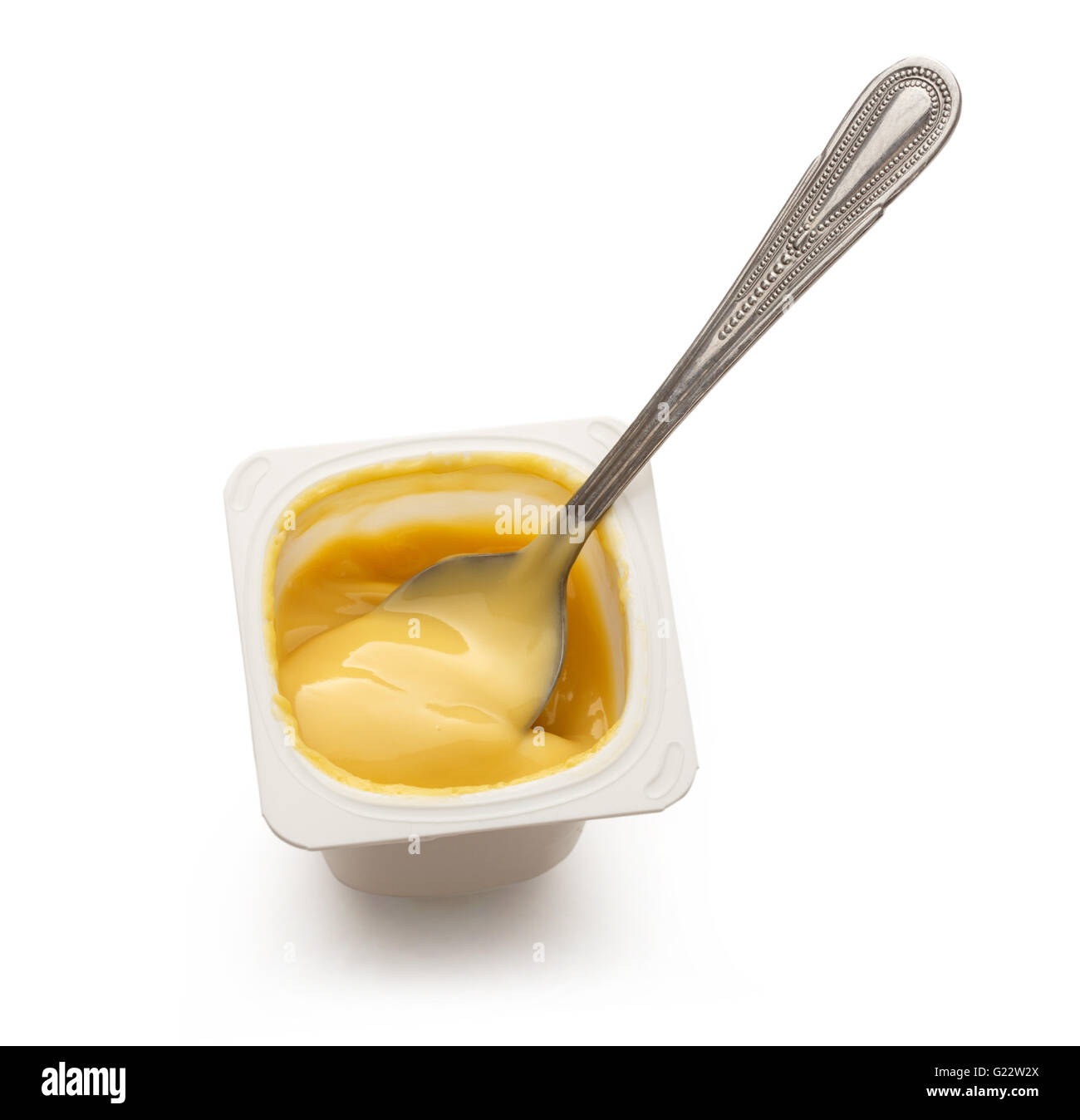 Open yogurt in pot with metal spoon closeup Stock Photo - Alamy