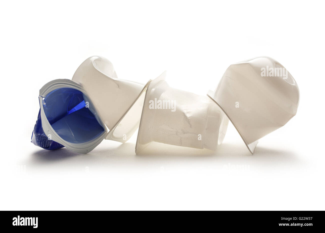 Empty crushed plastic yogurt pots on white Stock Photo - Alamy