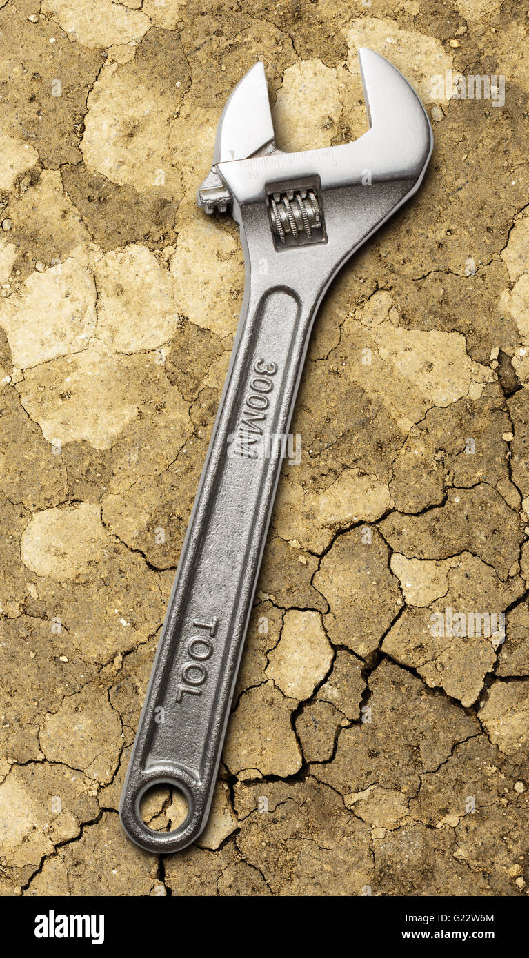 Metallic spanner on the cracked background closeup Stock Photo - Alamy