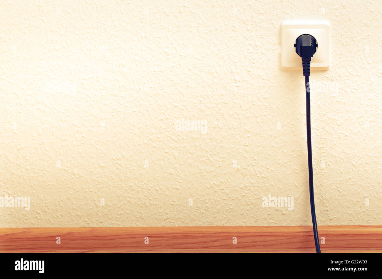 Single electric socket with plug on white wall Stock Photo - Alamy