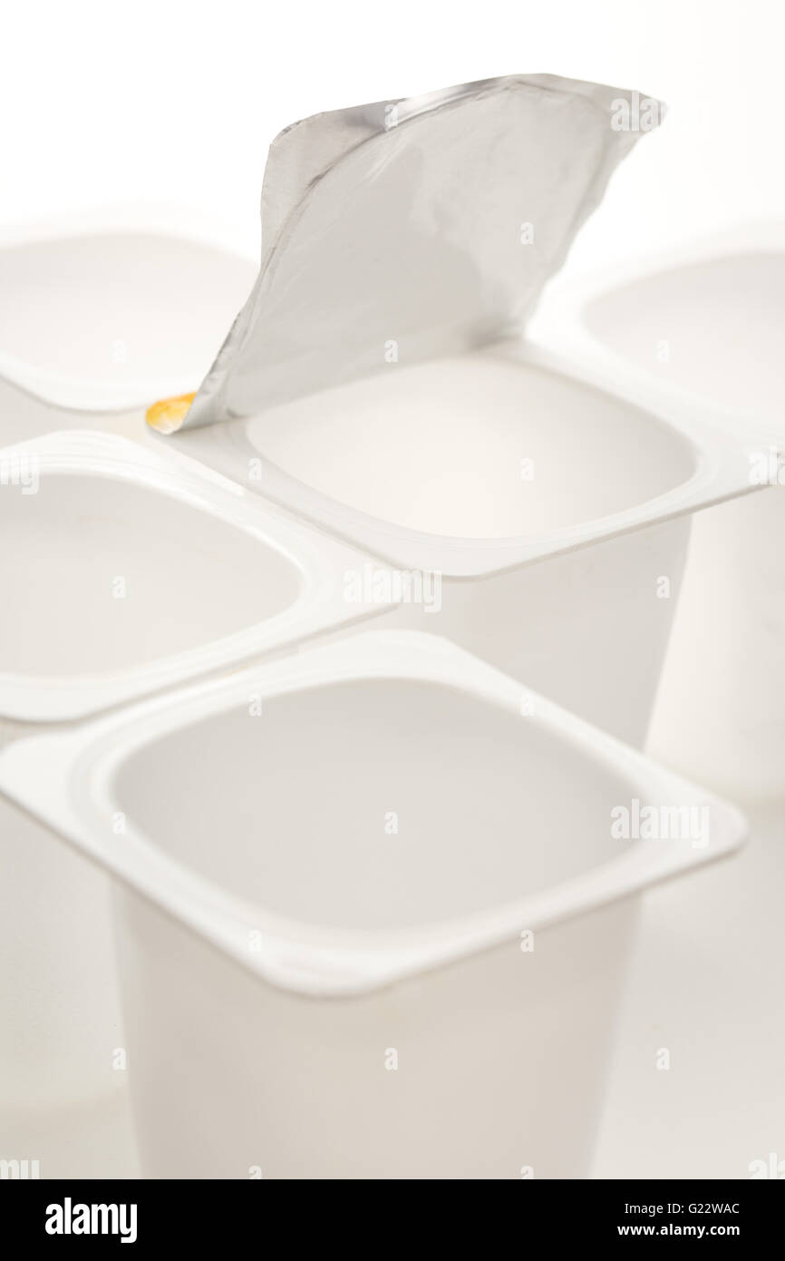 Empty crushed plastic yogurt pots on white Stock Photo - Alamy