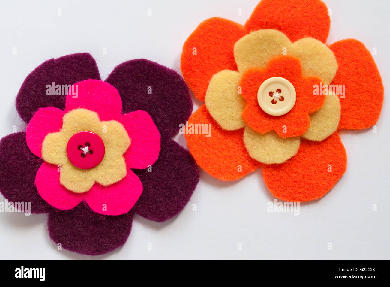 Handmade colourful badges made from felt and buttons isolated on white ...