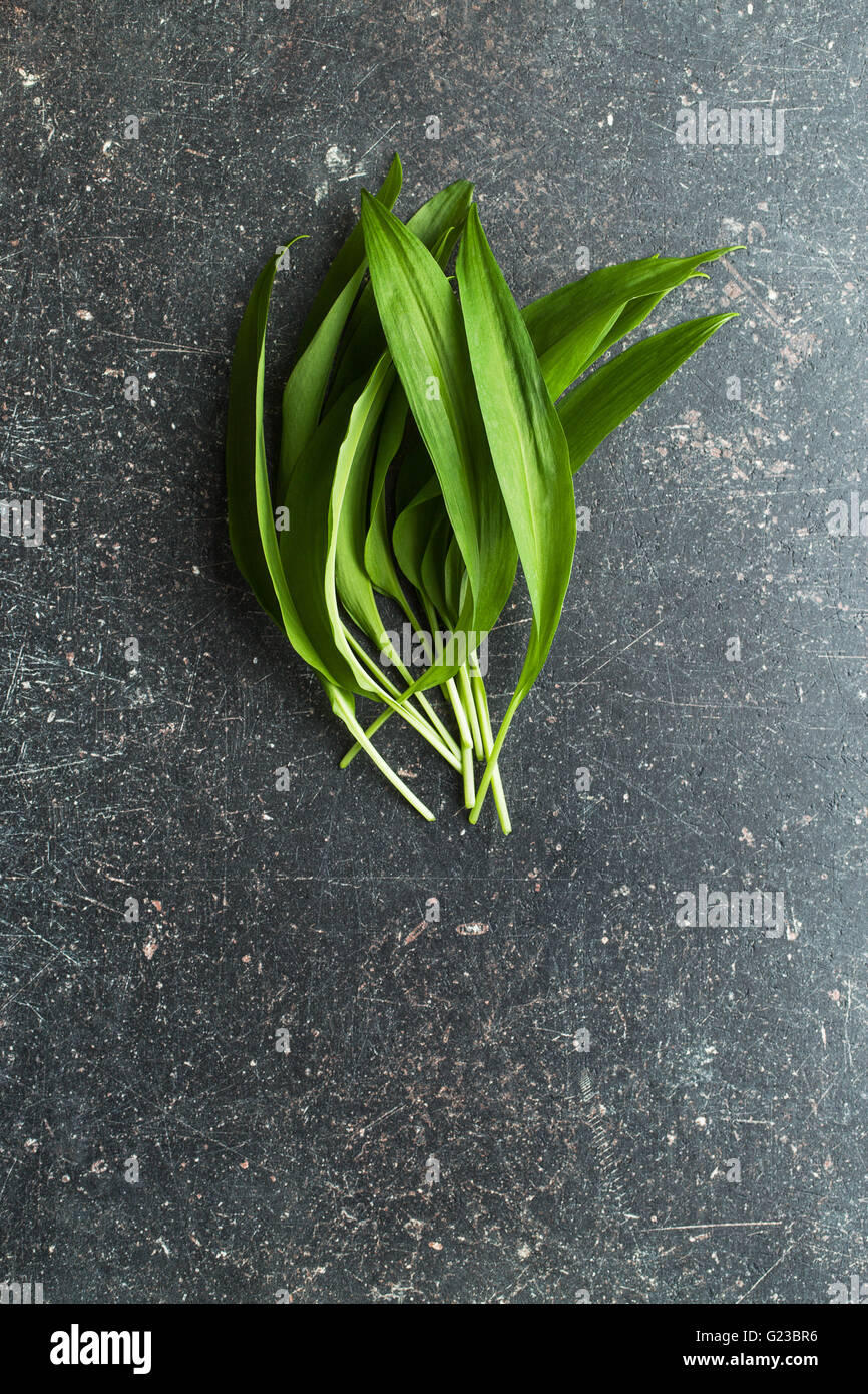 Fresh ramsons leaves. Wild garlic leaves on old kitchen table. Top view ...