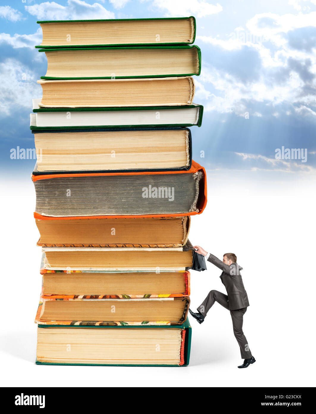 Pile of books with businessman climbing it Stock Photo - Alamy