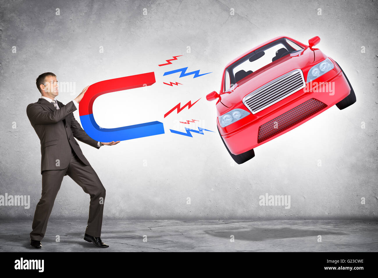 Businessman in suit holding big magnet Stock Photo - Alamy