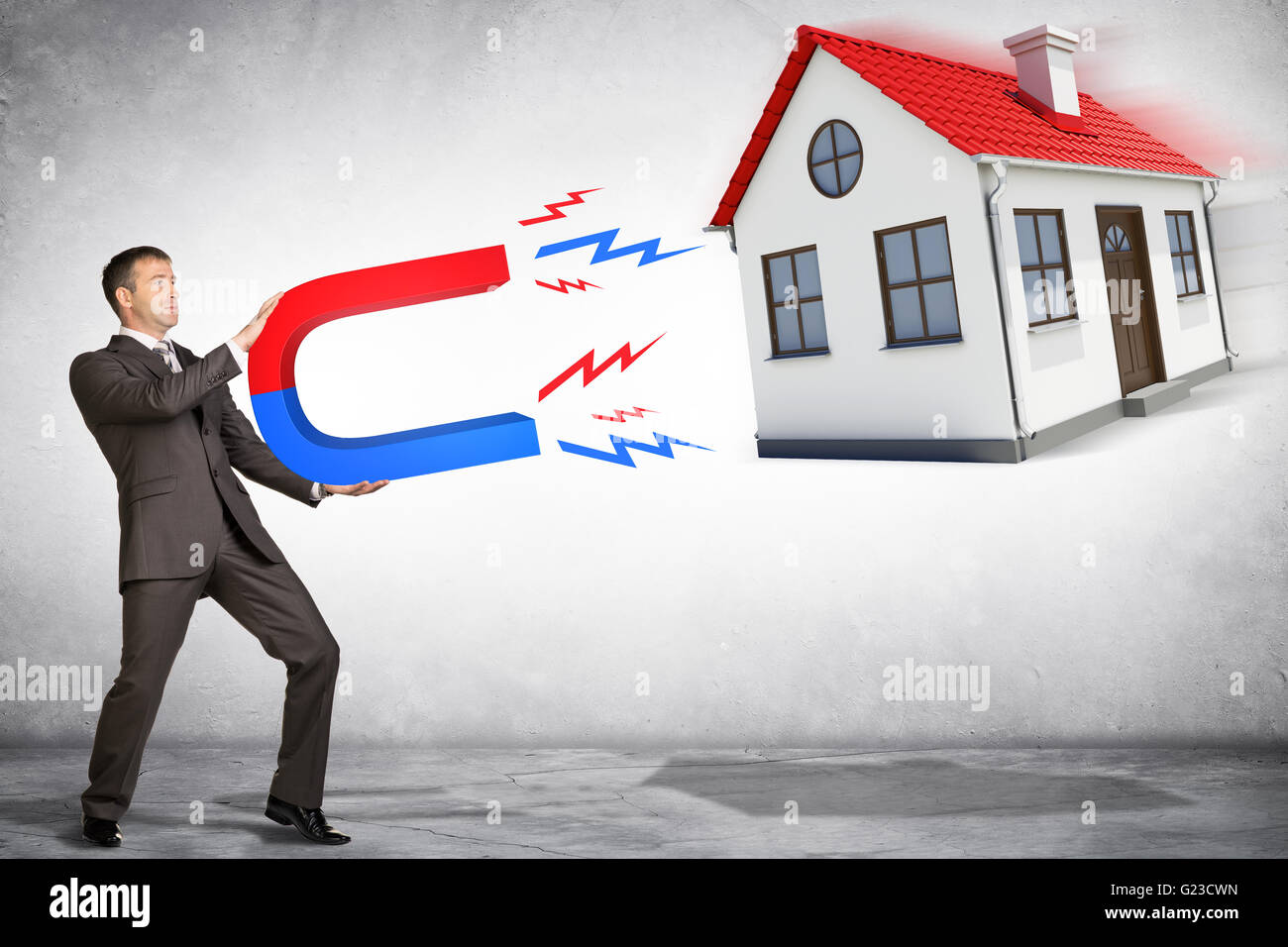 Businessman in suit holding big magnet Stock Photo - Alamy